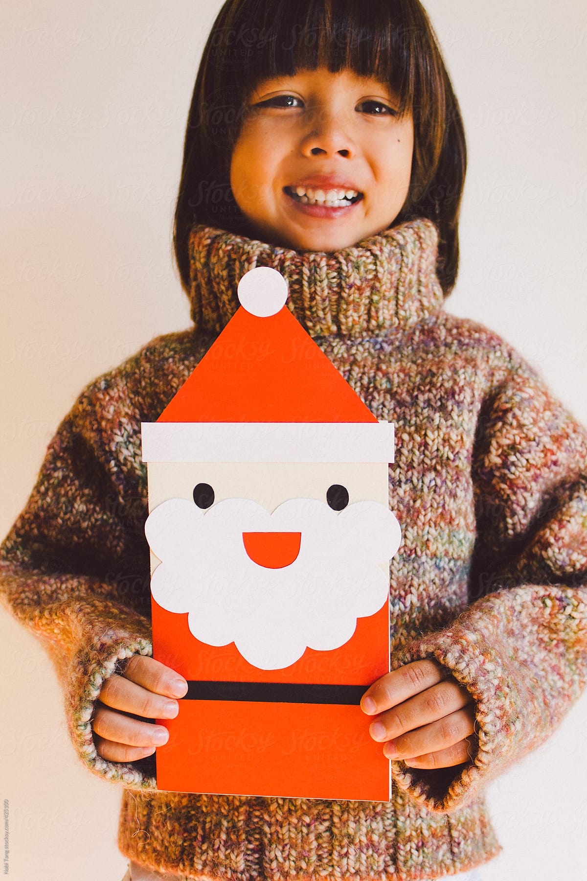 "A Boy Holding Big Santa Claus Card" by Stocksy Contributor "Nabi Tang ...