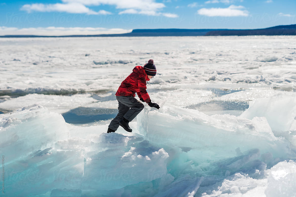 "Boy Clmbs Across Ice At Edge Of Vast Frozen Lake Landscape" by Stocksy ...