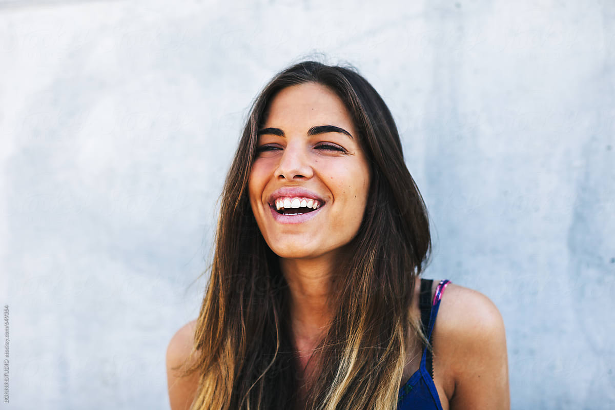 "Portrait Of A Young Beautiful Woman Laughing In Front Of A Wall." by ...