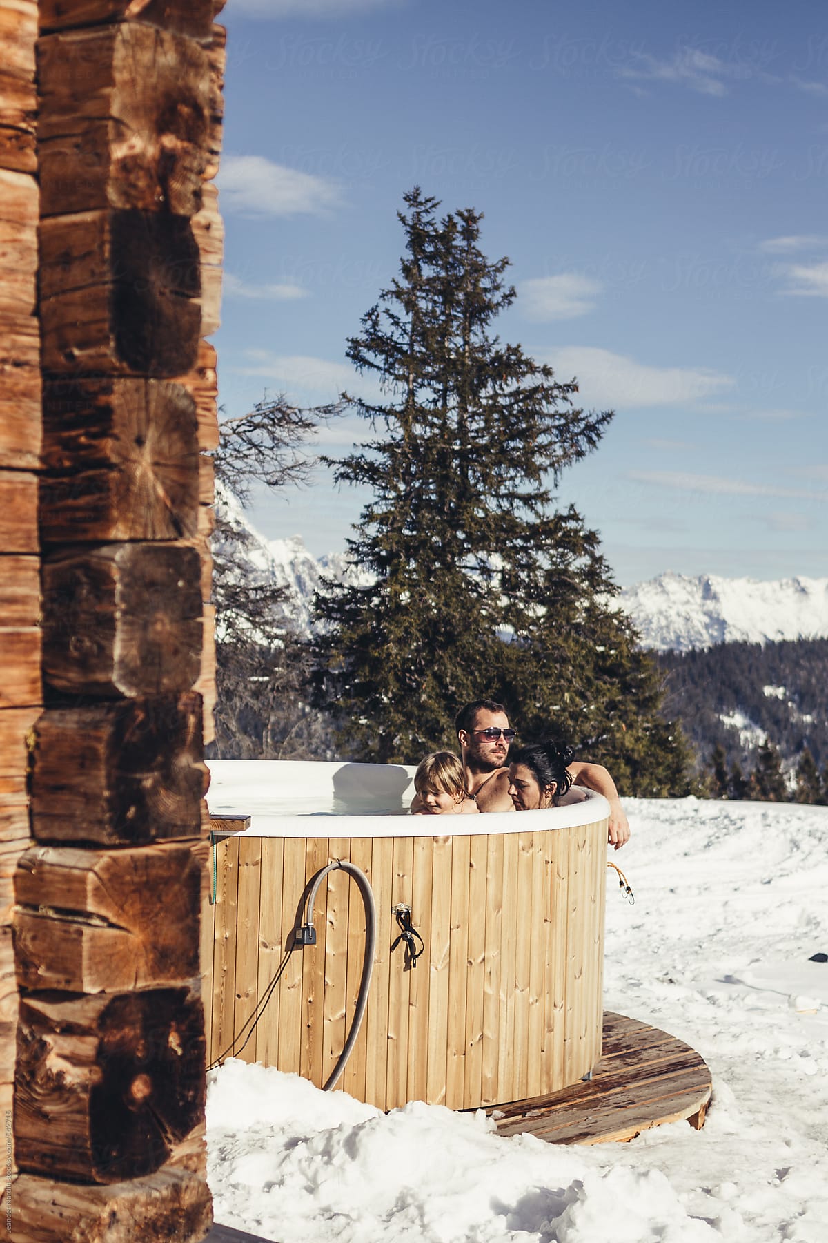 "Young Family Enjoying The Sun In An Outdoor Jacuzzi In Alpine Winter ...