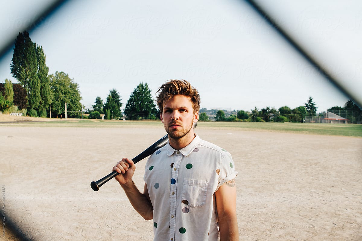 "Portrait Of Young Man Holding Bat On Baseball Field" by Stocksy ...
