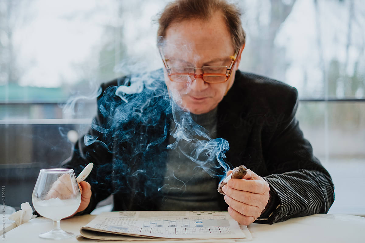 "Man Smoking And Drinking At Bar" by Stocksy Contributor "Sergio Murria ...