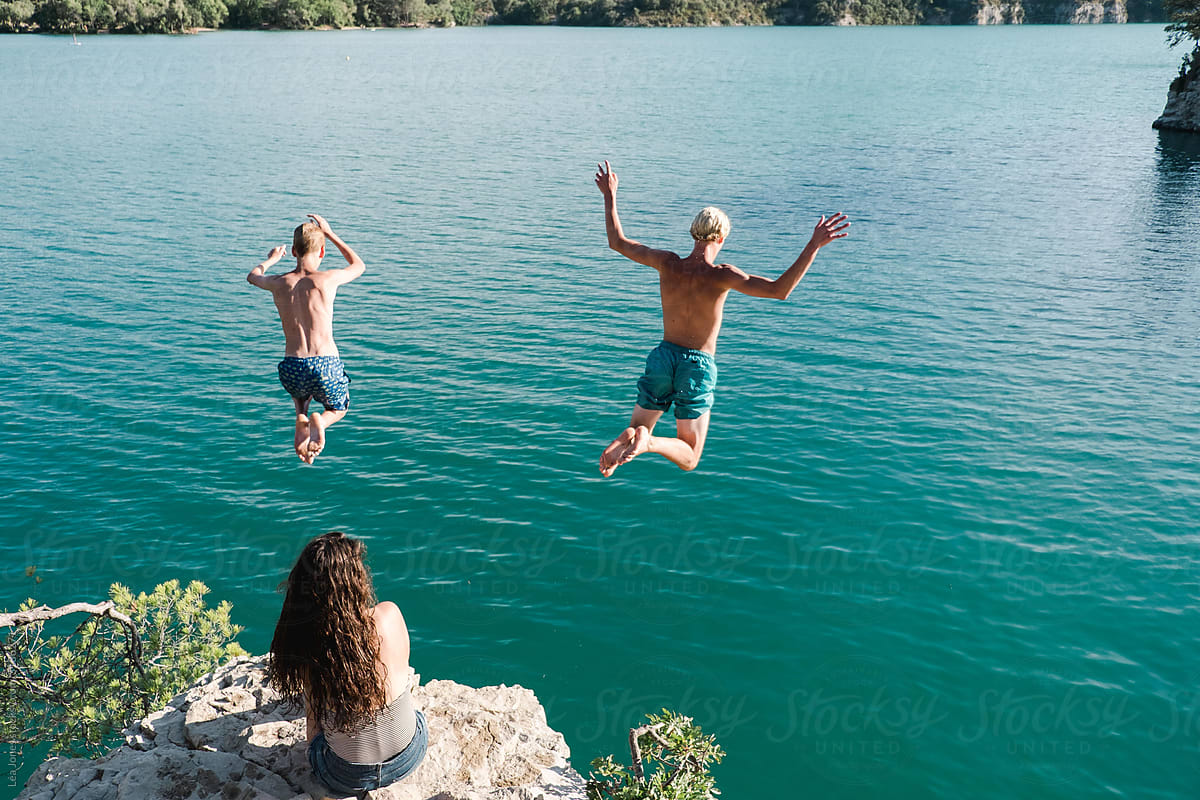 "Teen Boys Jumping From Cliff While Girl Is Looking On." by Stocksy ...