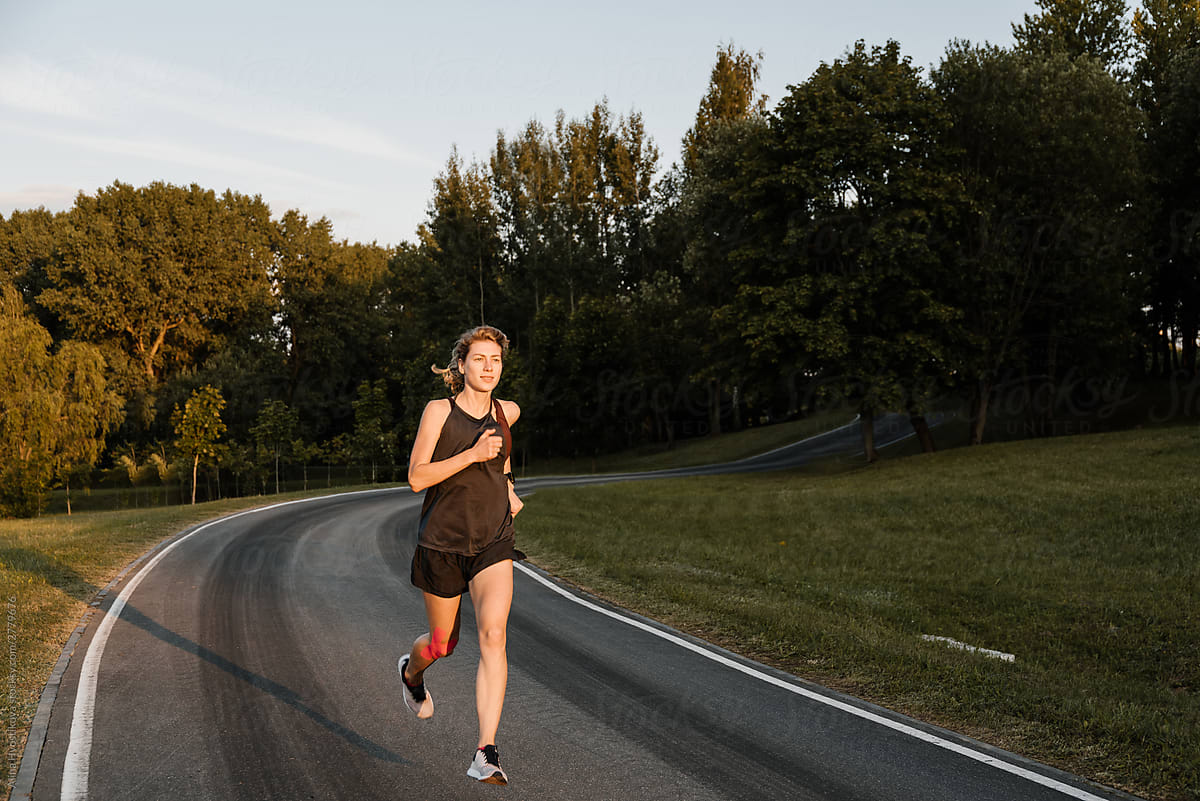 "Fit Young Woman Running Through City Park Road" by Stocksy Contributor ...
