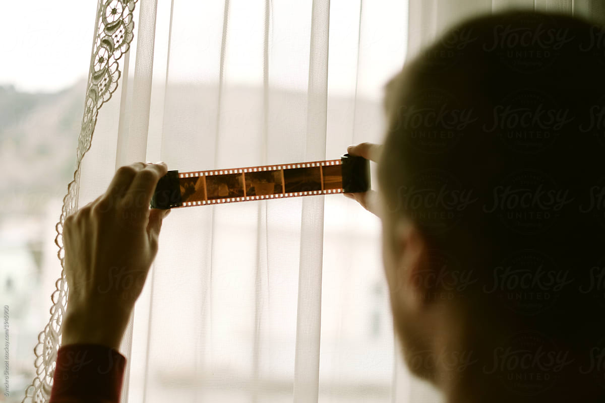 "Young Man Looking At The Film Roll" by Stocksy Contributor "Synchro ...