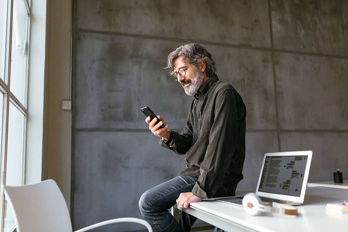"Senior Employee Using Smartphone In Office" by Stocksy Contributor ...