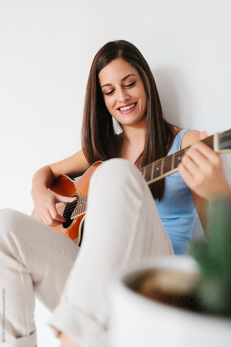 "Woman Playing Acoustic Guitar At Home" by Stocksy Contributor "VICTOR ...