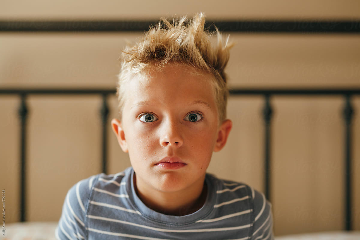  Wide Eyed Child Sitting Up In Bed In The Morning By Stocksy