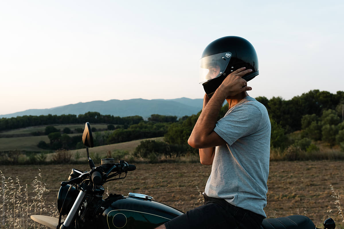 "Biker Putting On Helmet Before Ride" by Stocksy Contributor "Milles ...