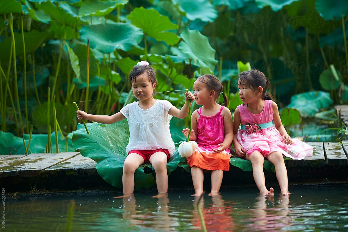 "Three Little Girls Sitting By The Pond Playing Water" by Stocksy ...