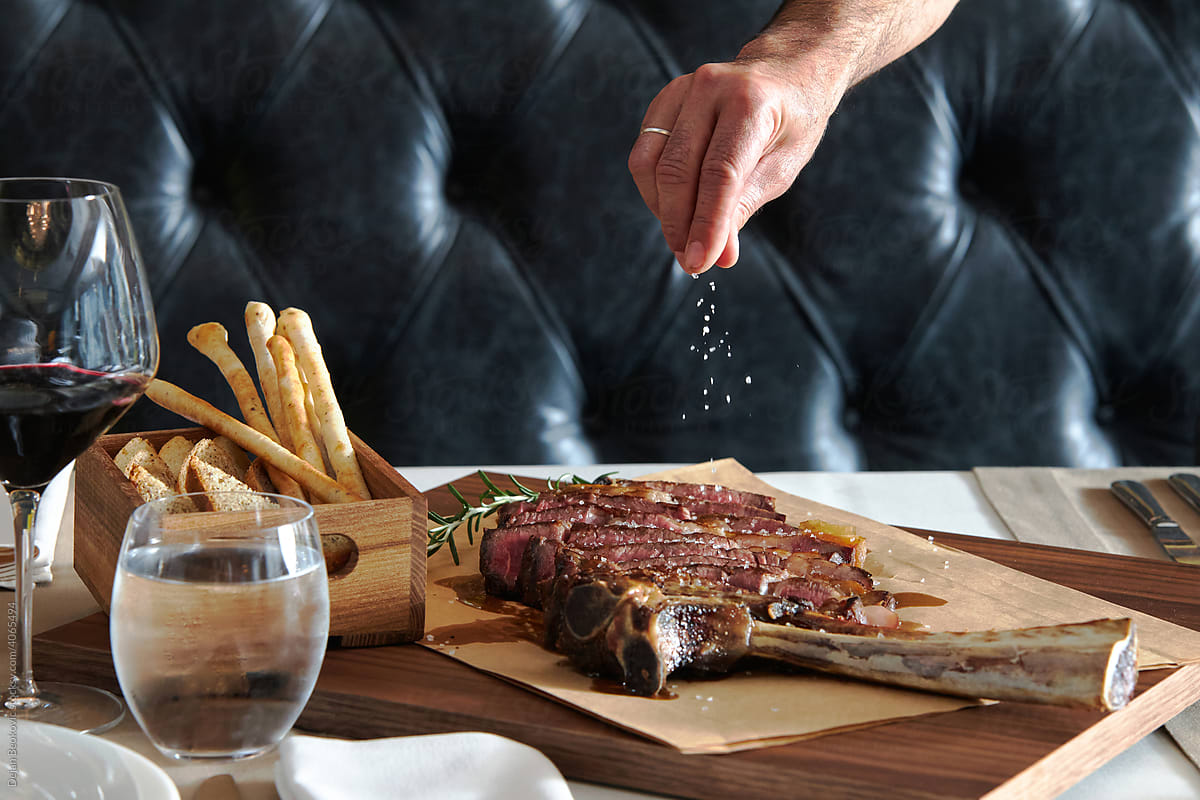 "Sliced Tomahawk Steak." by Stocksy Contributor "Dejan Beokovic" - Stocksy