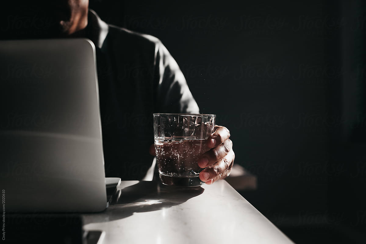 "Anonymous Man Behind Laptop Holding A Glass Of Sparkly Water" by ...