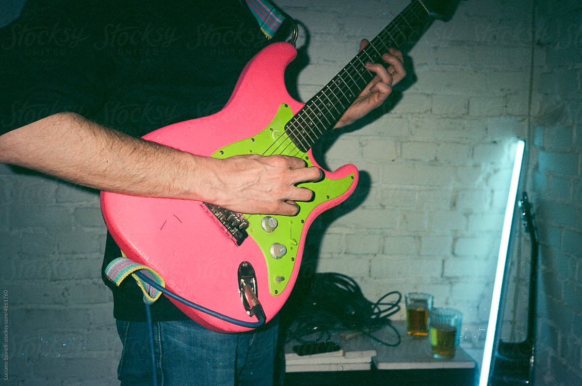 "Anonymous Guitarist Play A Flashy Pink And Green Guitar And Do A Chord ...