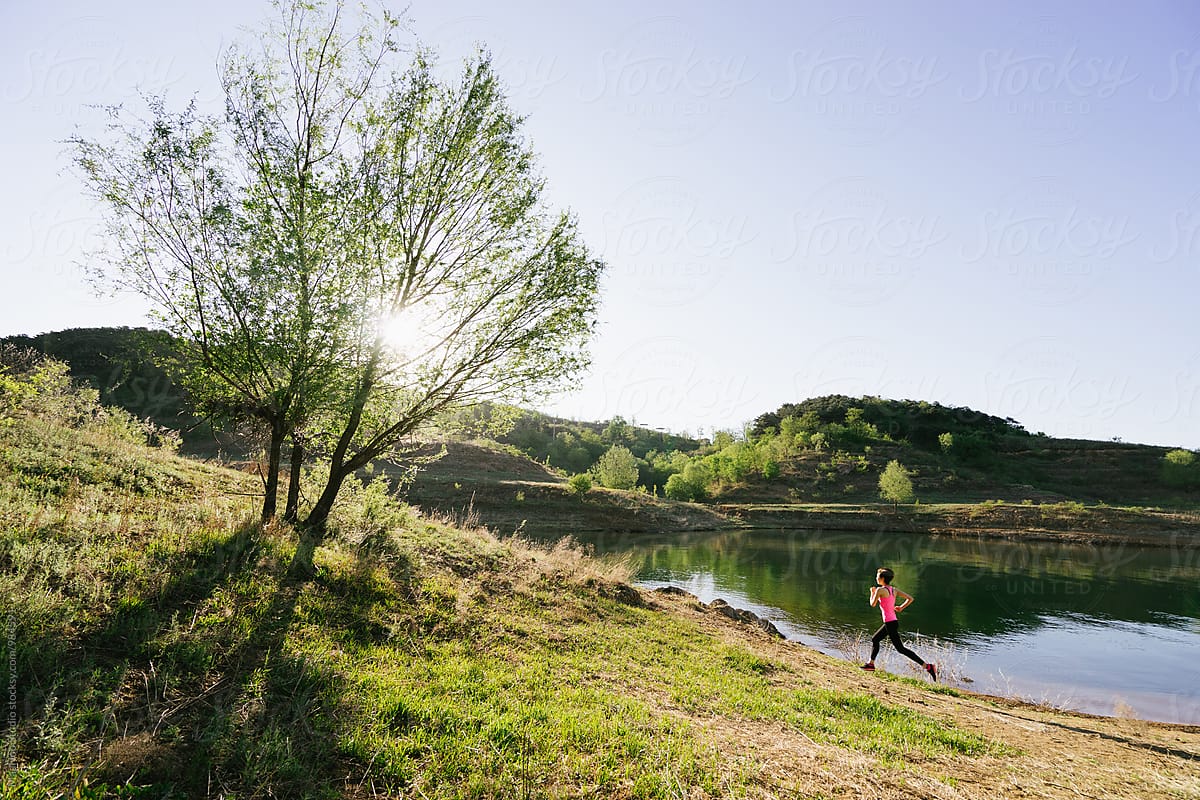 "Young Woman Running Beside A Lake" by Stocksy Contributor "MaaHoo ...