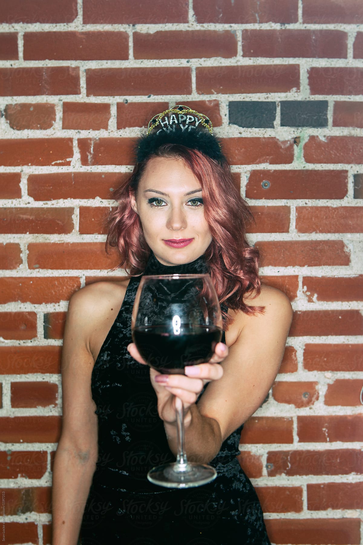 "NYE: Woman Poses Against Brick Wall With Wine" by Stocksy Contributor ...