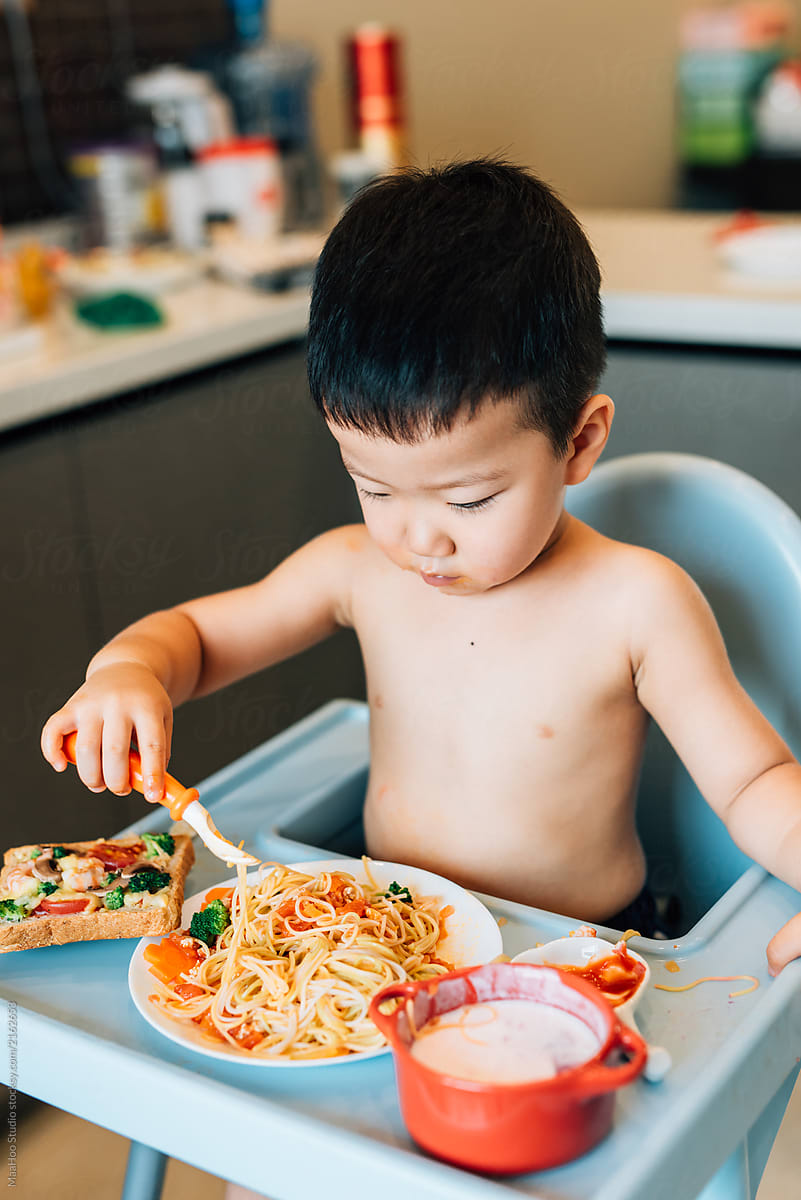 "Adorable Boy Eating At Home" by Stocksy Contributor "MaaHoo" - Stocksy