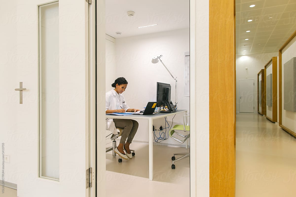"Female Doctor Doing Paperwork In White Office Cubicle" by Stocksy ...