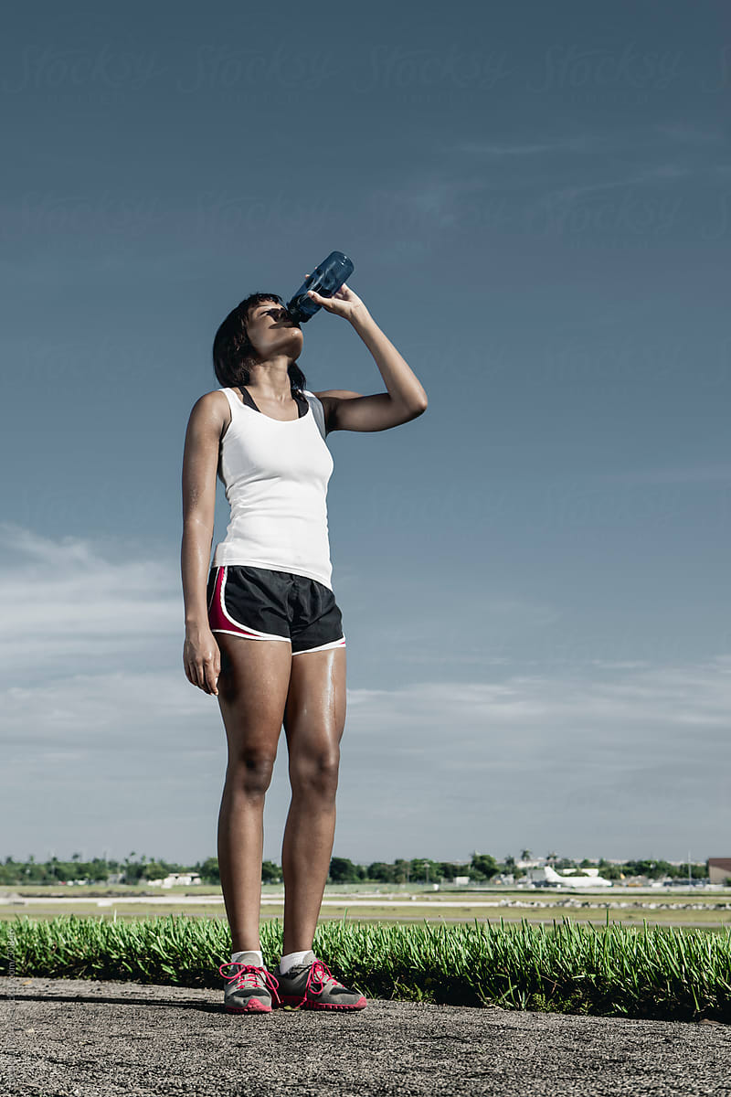 "Woman Runner Drinking Water" by Stocksy Contributor "Stephen Morris ...