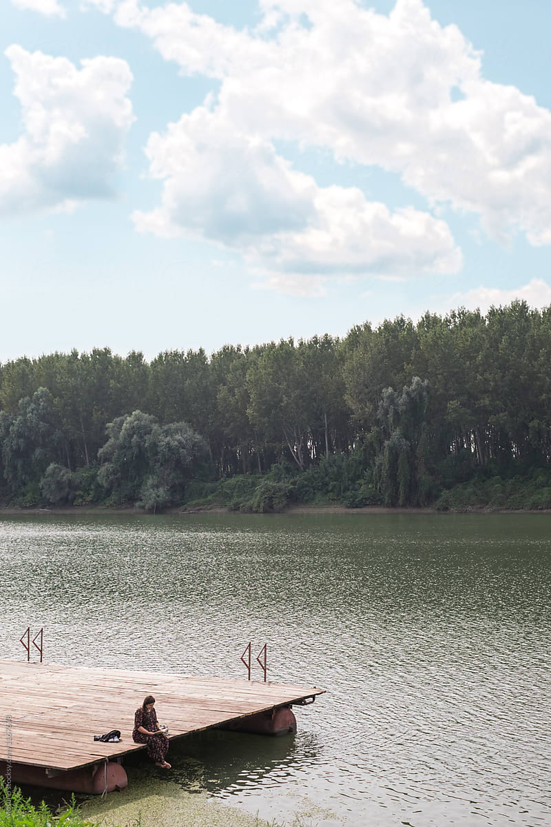"Woman Reading A Book By The River" by Stocksy Contributor "Mosuno ...