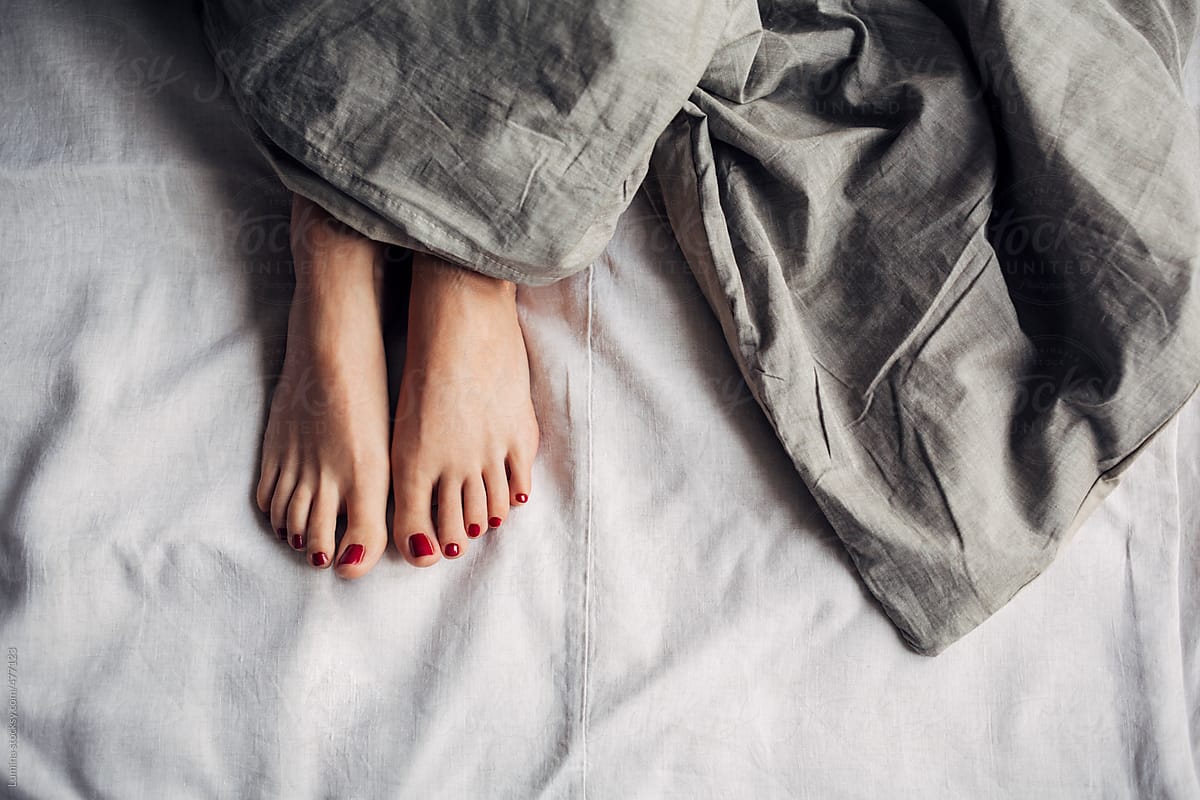 "Woman's Feet Under A Duvet" by Stocksy Contributor "Lumina" - Stocksy