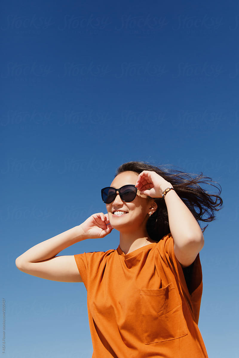 "Happy Asian Young Woman Standing With Flying Hair" by Stocksy ...