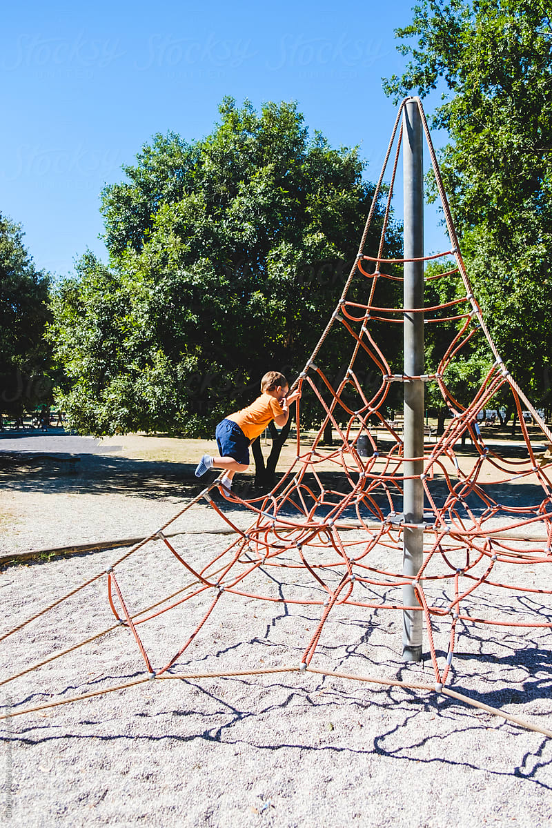 "Happy Male Toddler Climbing A Net At The Playground" by Stocksy ...