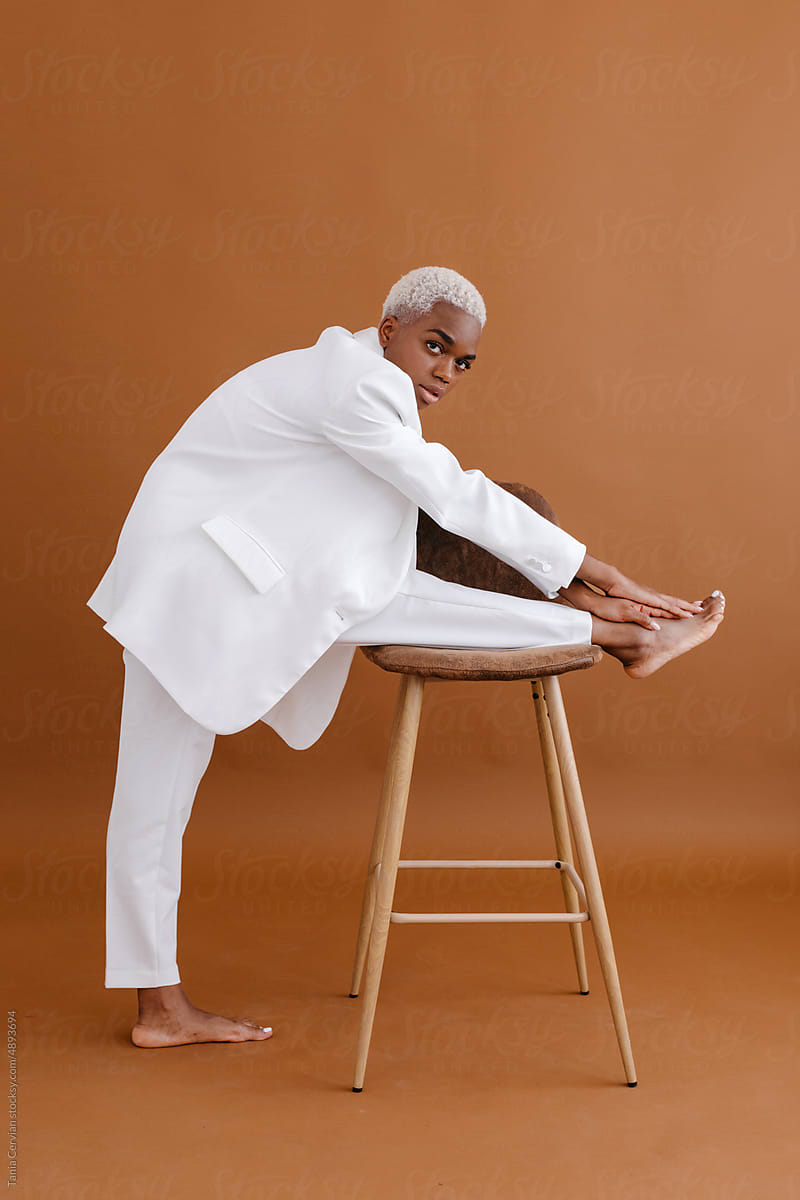"Elegant Black Female Model Putting Leg On Chair" by Stocksy ...