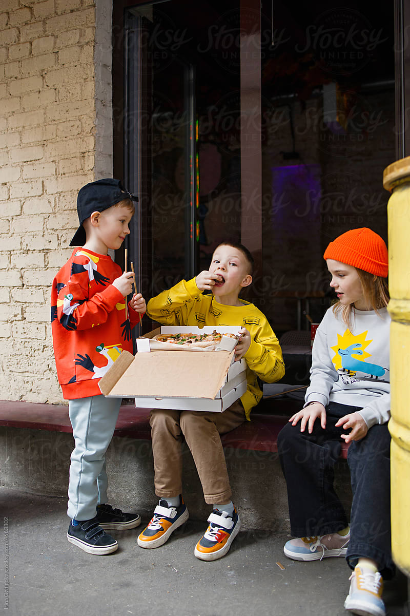 "Happy Kids Eating Pizza" by Stocksy Contributor "Irina Ozhigova" - Stocksy
