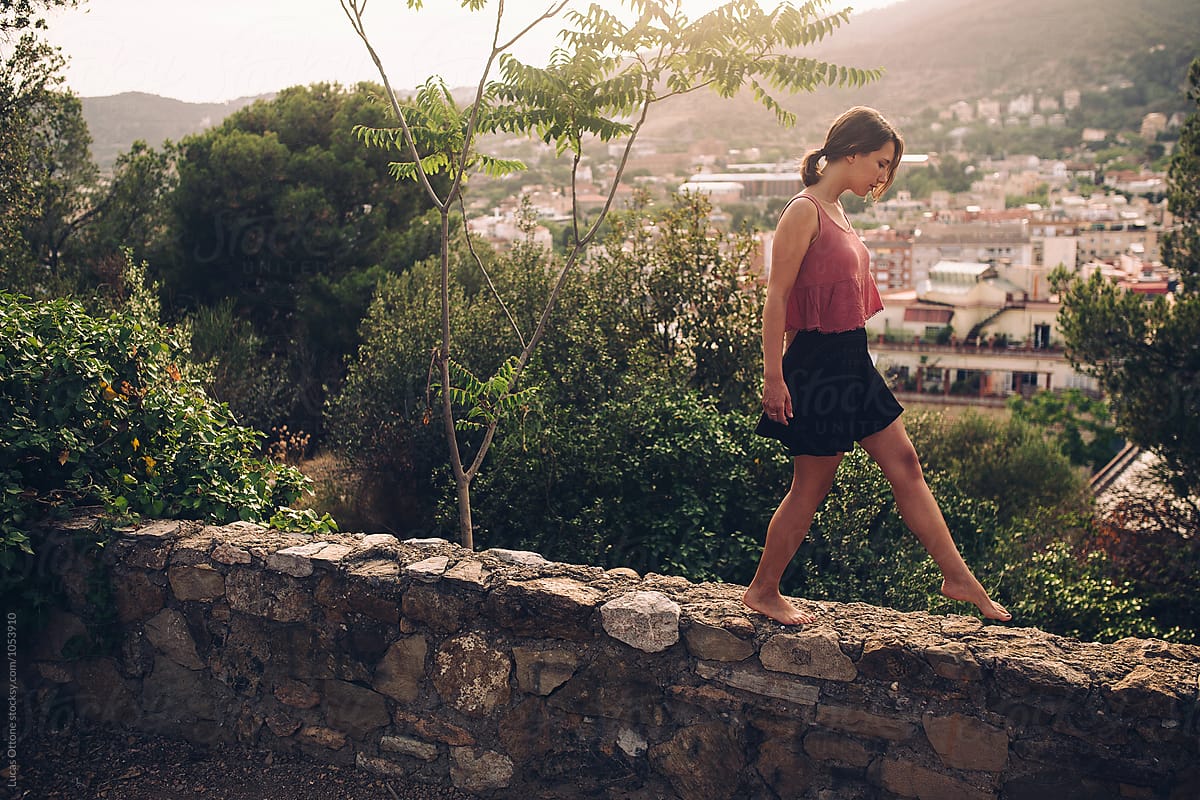 "Young Woman Walking Over A Rock Wall" by Stocksy Contributor "Lucas ...