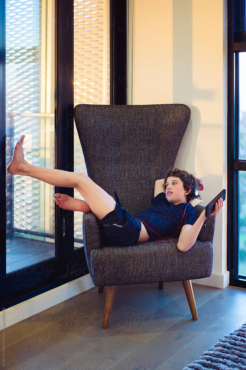 "Boy Relaxing On A Chair And Wearing Headphones" by Stocksy Contributor ...