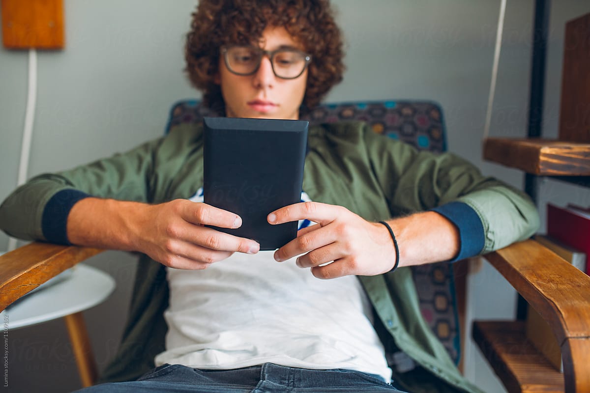 "Young Man Reading From A Tablet" by Stocksy Contributor "Lumina" - Stocksy