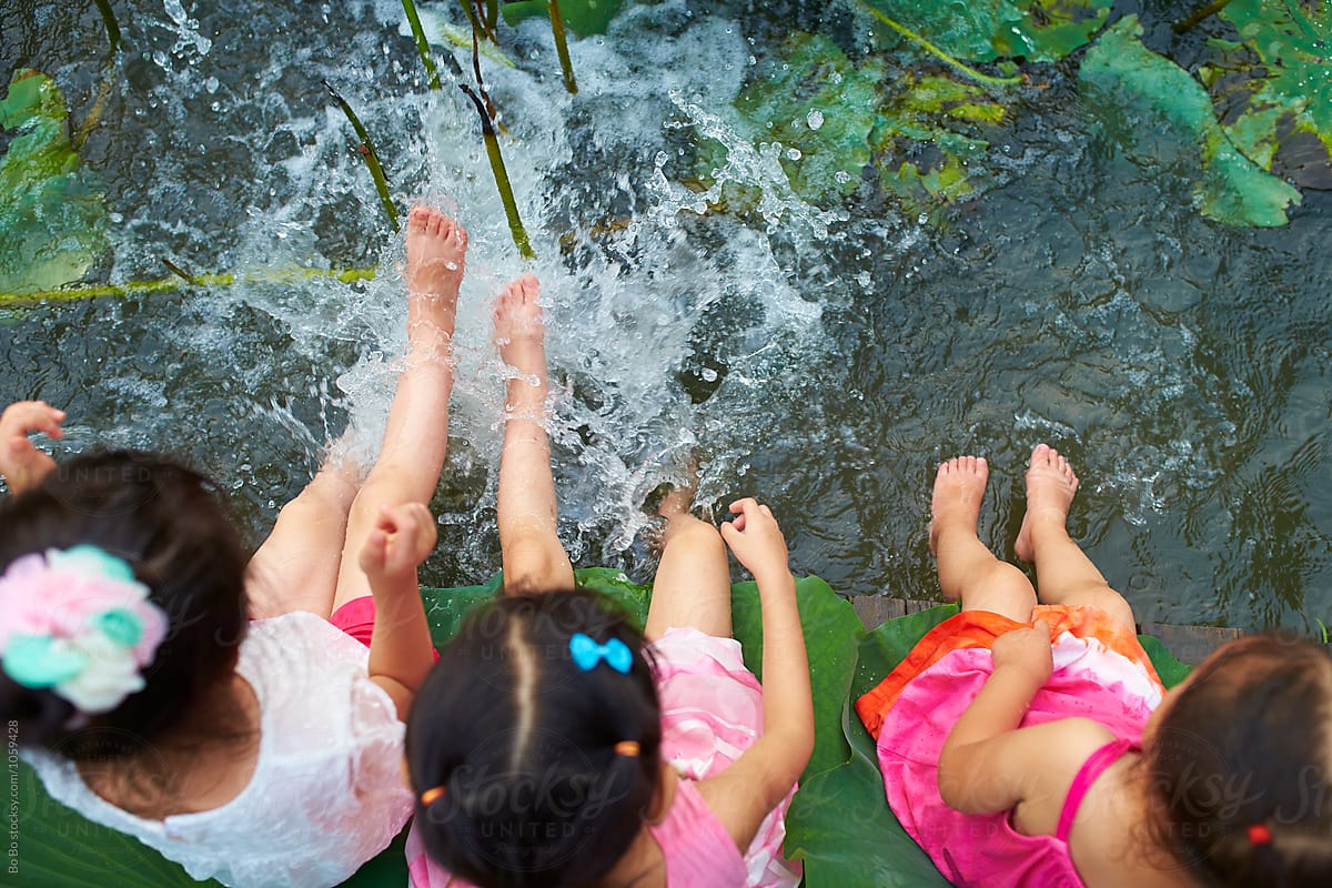 "Three Little Girls Sitting By The Pond Playing Water" by Stocksy ...