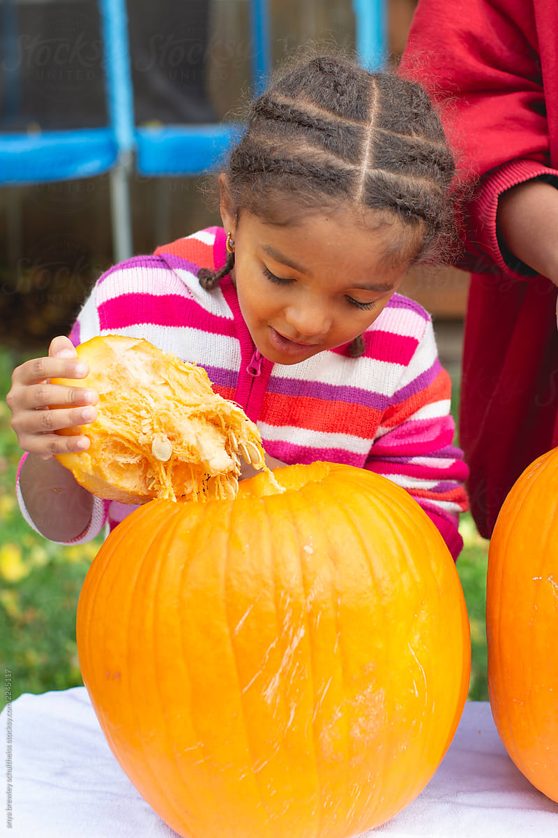 "Young Girl Opening The Top Of A Recently Cut Pumpkin" by Stocksy ...