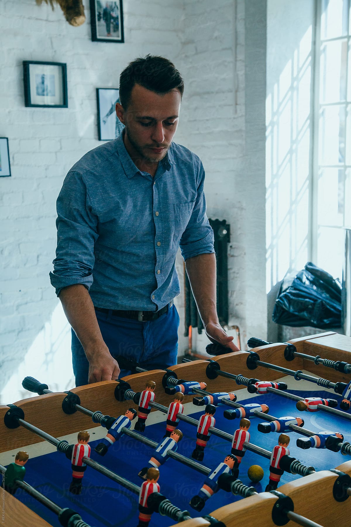 "Young Man Playing Table Football" by Stocksy Contributor "Danil Nevsky ...