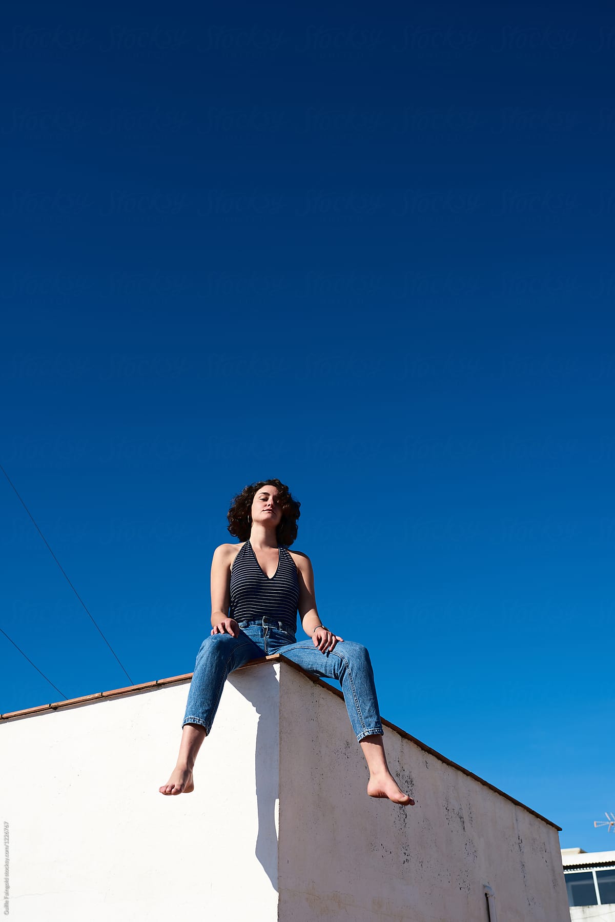 "Woman Sitting On Building Roof." by Stocksy Contributor "Guille ...