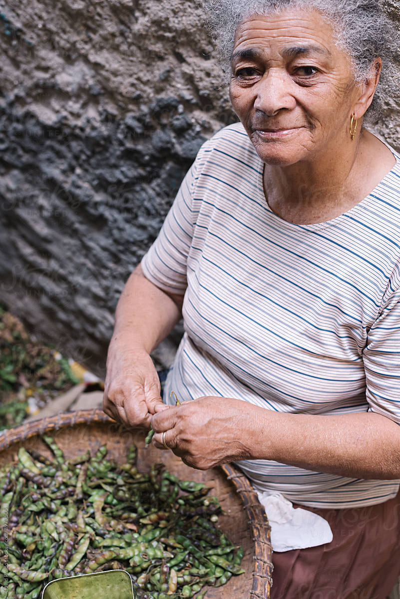 "Aged Woman Shelling Beans While Sitting On Street" by Stocksy ...