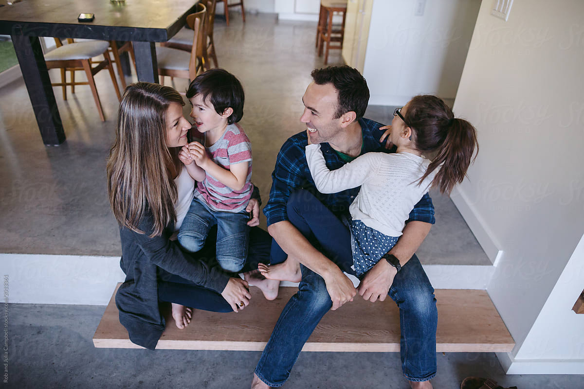 "Happy Family Of Four Sitting Together At Home" by Stocksy Contributor ...
