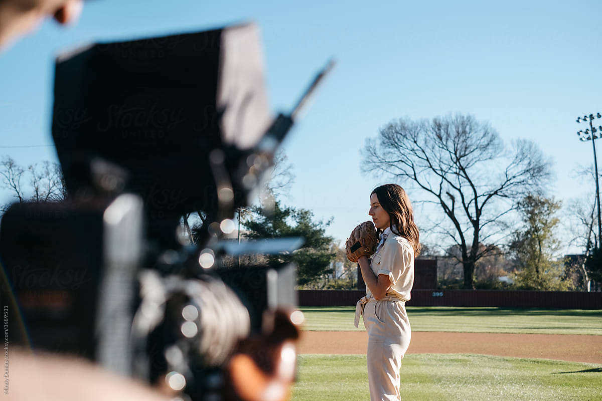 "Cinematographer Filming A Female Pitcher On A Baseball Field" by ...