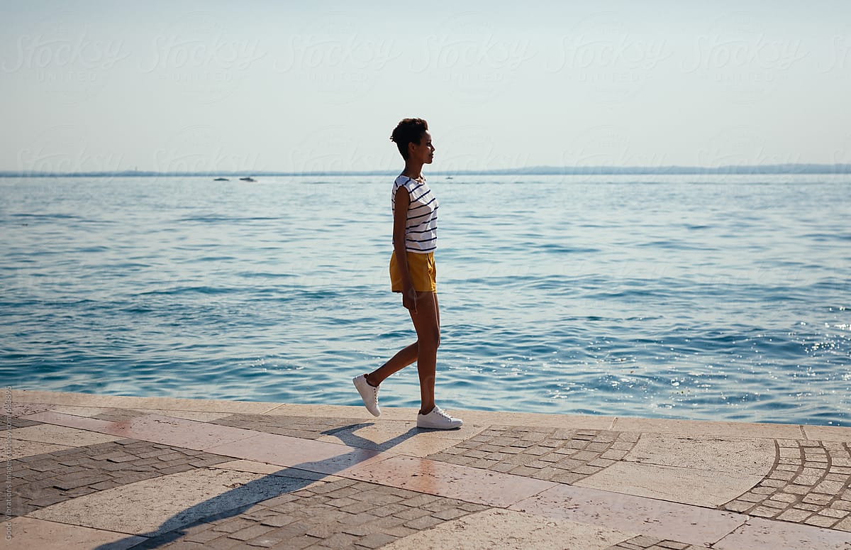 "Woman Walking By The Lake" by Stocksy Contributor "Vero." - Stocksy