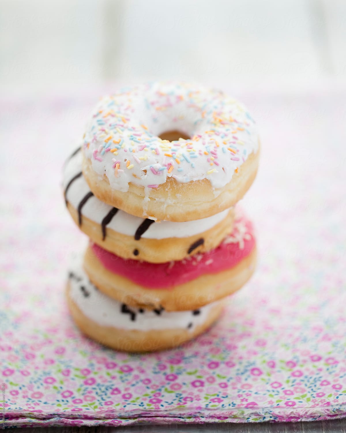 "Four Different Flavored Doughnuts On Flowered Cotton Cloth On Wooden ...