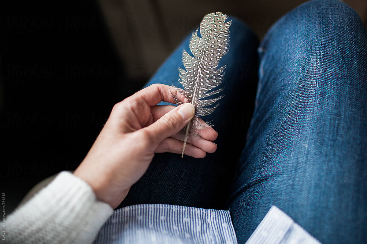 "Hand Holding A Feather" by Stocksy Contributor "Kelly Knox" - Stocksy
