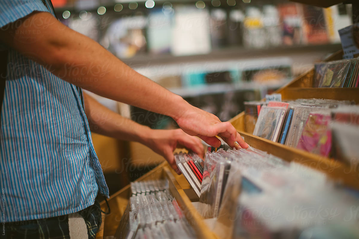 "Man Shopping For CDs" by Stocksy Contributor "Lauren Lee" - Stocksy
