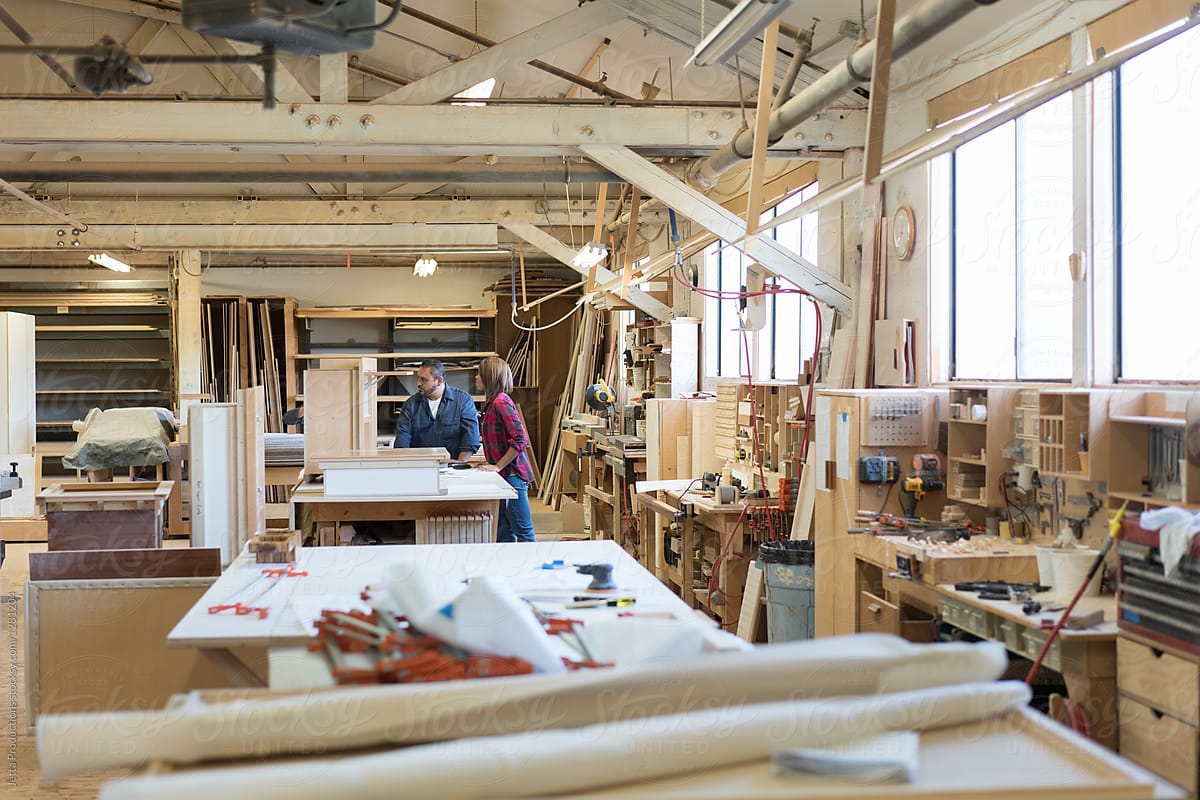 "Two Workers In The Distance Meet In A Cabinet Shop" by Stocksy ...