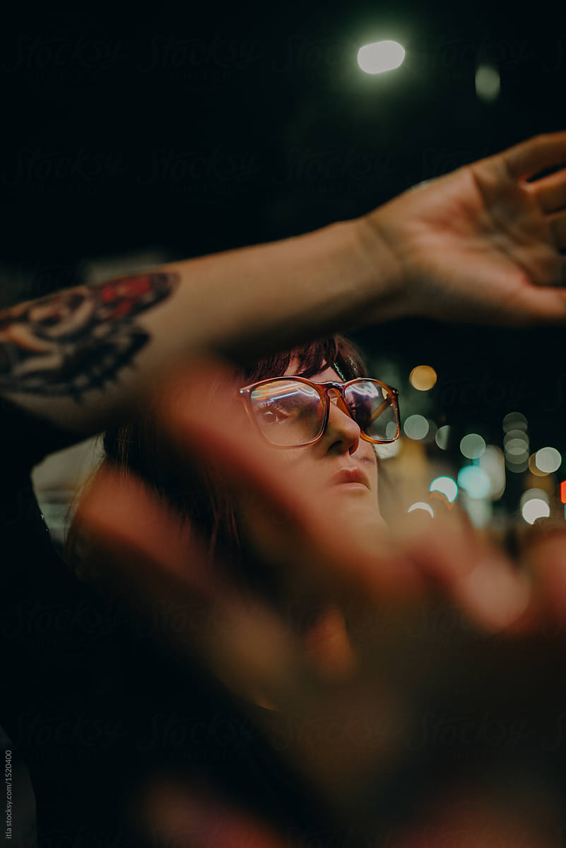 "A Woman In The Night Lights With Her Arms Artistically Framing Her ...
