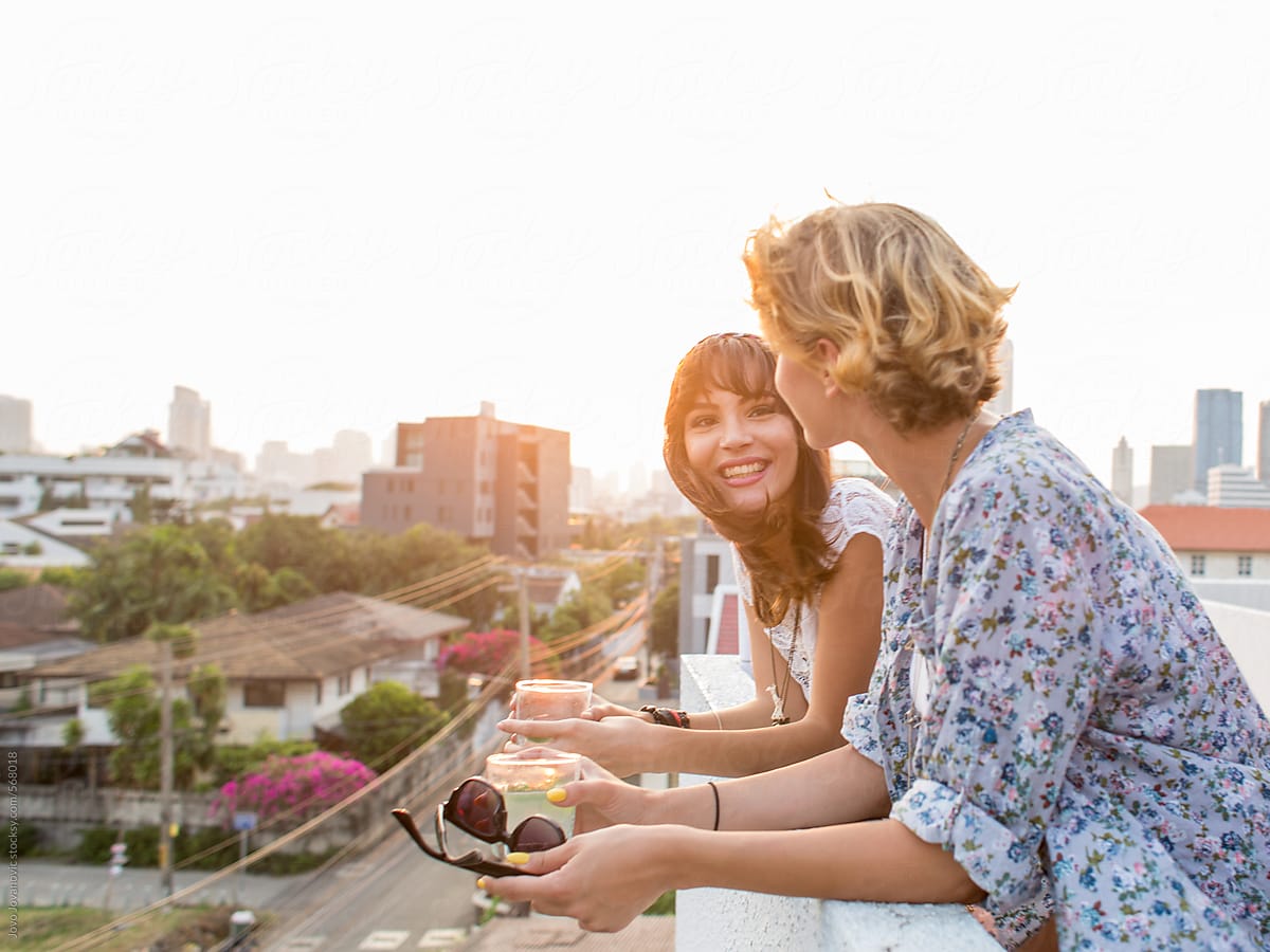 "Two Friends In Conversation At Sunset On A Balcony" by Stocksy ...