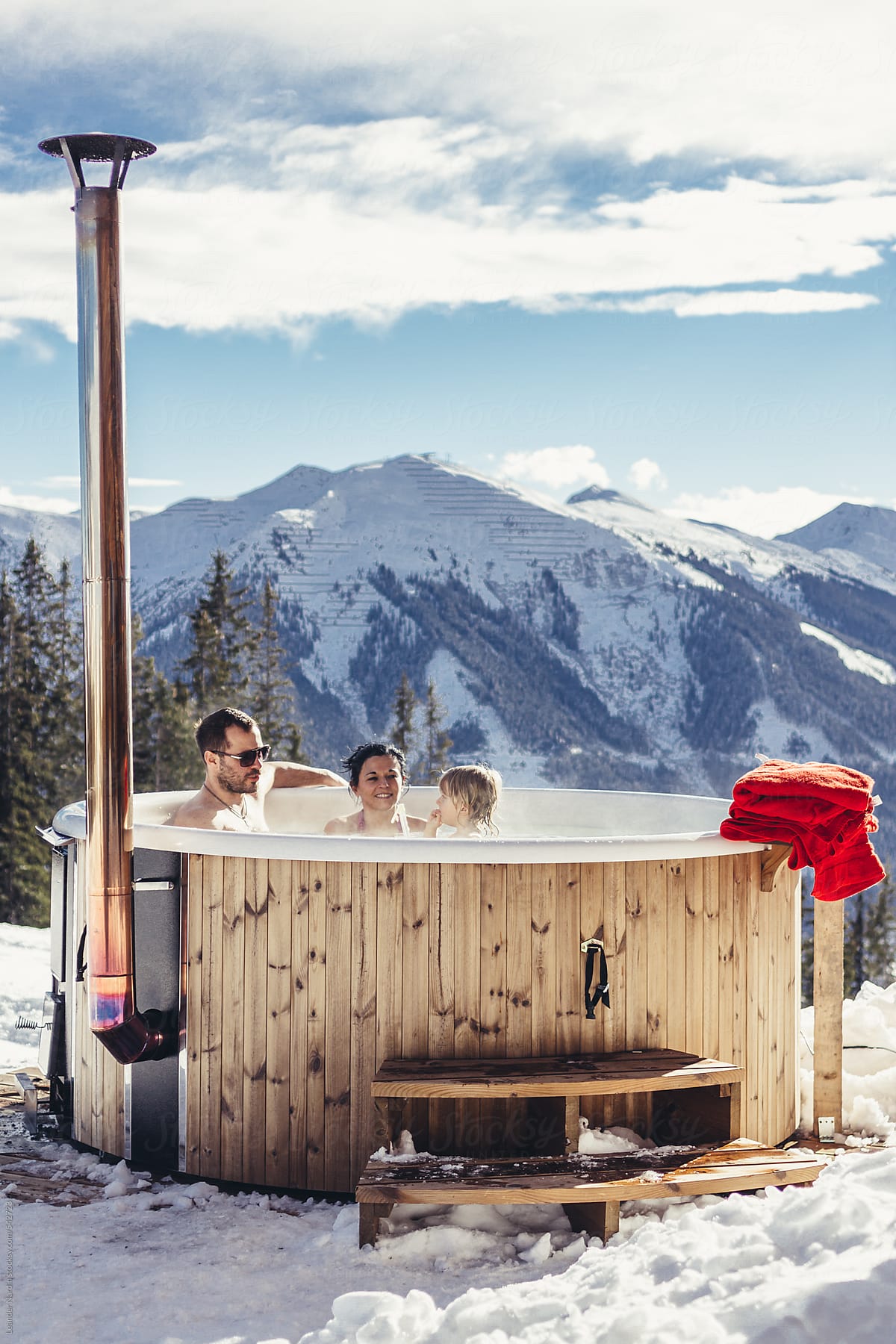 "Young Family In Outdoor Jacuzzi In Snowcovered Alpine Winter Landscape ...