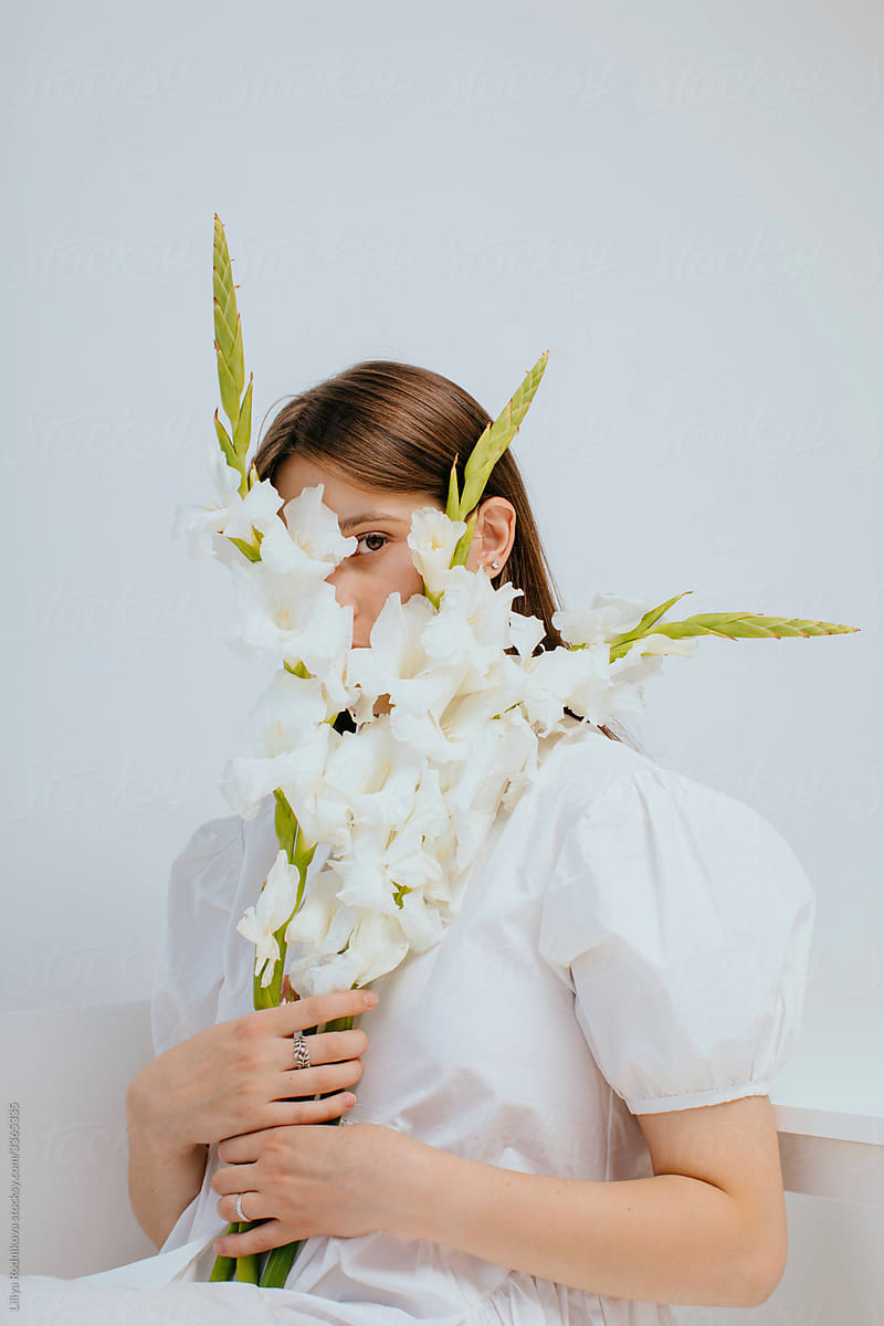 "Portrait Of Young Woman Hiding Behind Bouquet Of White Flowers" by ...