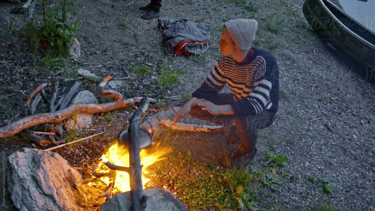 "Young Traveler Warming By Fire" by Stocksy Contributor "Clique Images ...