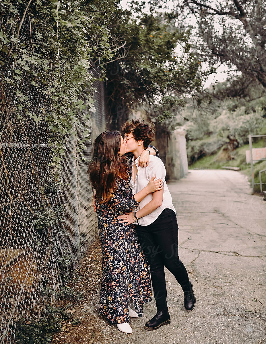 "Two Gay Woman On A Date In Nature Kissing Next To A Chain Fence" by ...