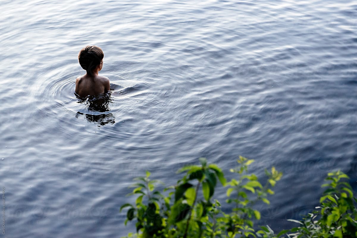 "Boy Wades In Shallow Lake Water At Sunset" by Stocksy Contributor ...